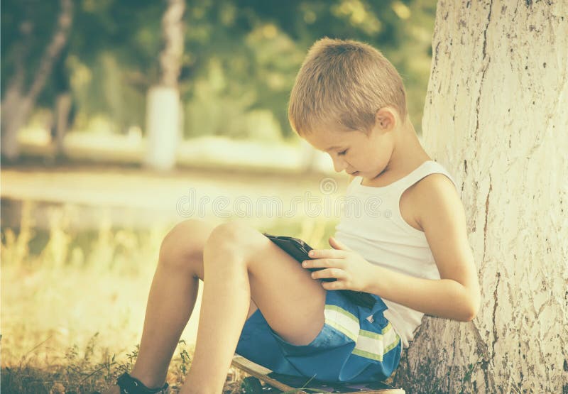 Criança Do Menino Que Joga Com Pc Da Tabuleta Imagem De Stock Imagem