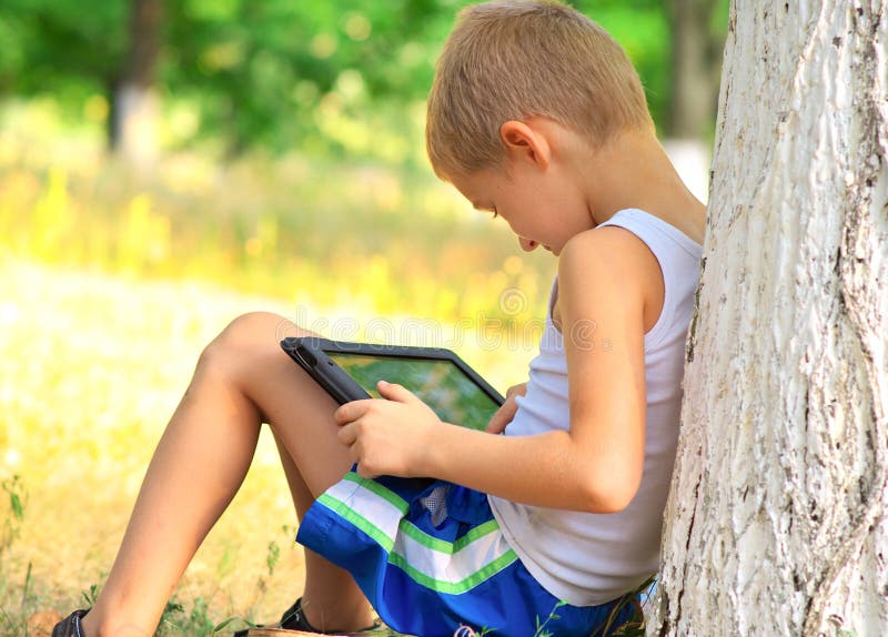 Criança Do Menino Que Joga Com Pc Da Tabuleta Imagem De Stock Imagem