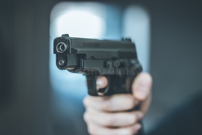 Crime or Robbery Concept: Man with Black Gun is Aiming with His Weapon ...
