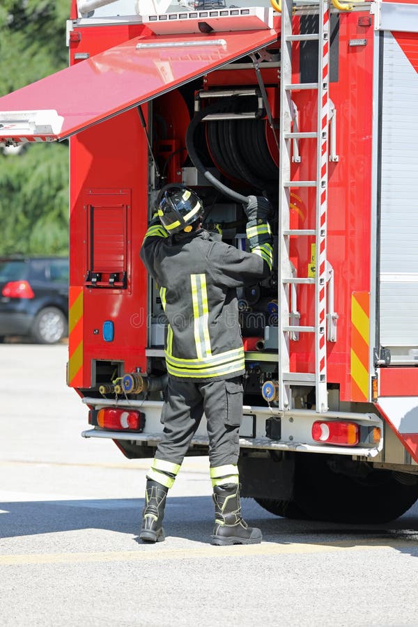 During a Crisisa a Courageous Firefighter is Unloading Tools from the ...