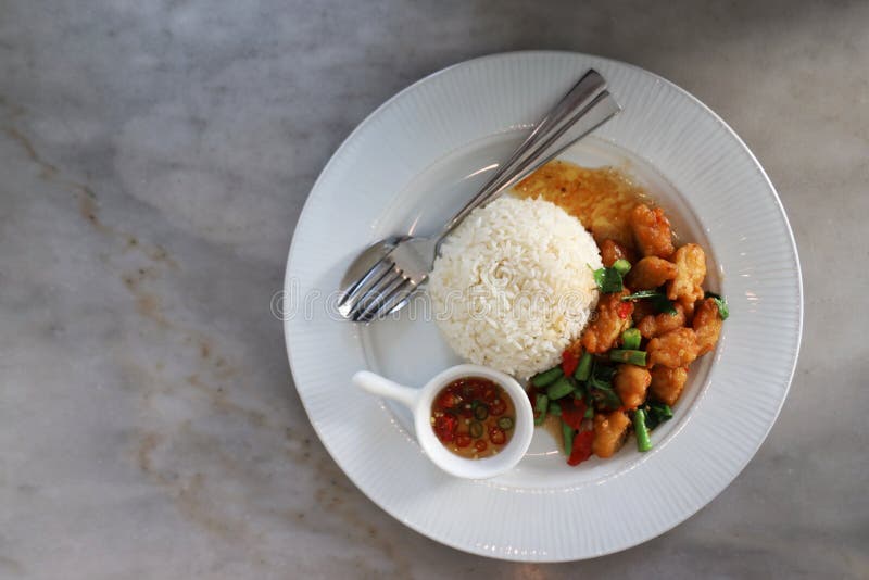 Crispy Chicken with Basil in a White Circular Dish Placed on a Marble ...