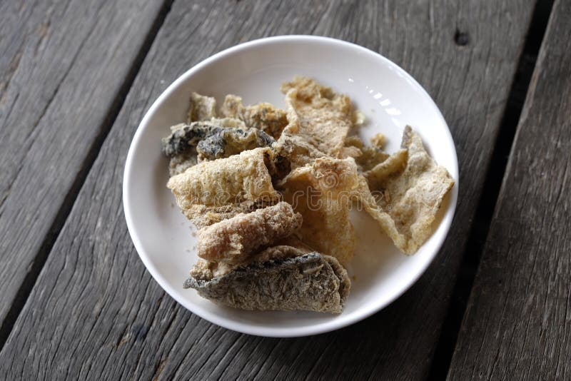 Bowl of crispy fish skin stock photo. Image of filleted - 217549018