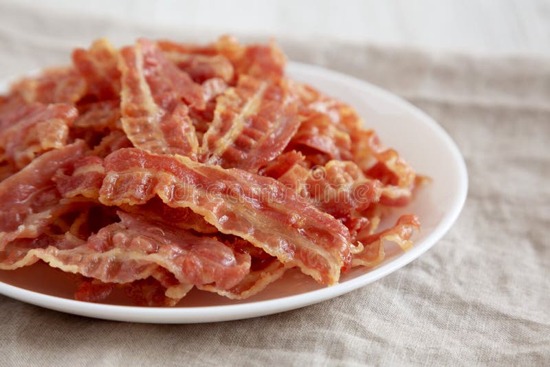 Crispy Fried Bacon on a White Plate, Side View. Close-up Stock Image ...