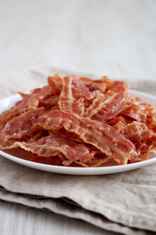Crispy Fried Bacon on a White Plate, Side View. Close-up Stock Photo ...