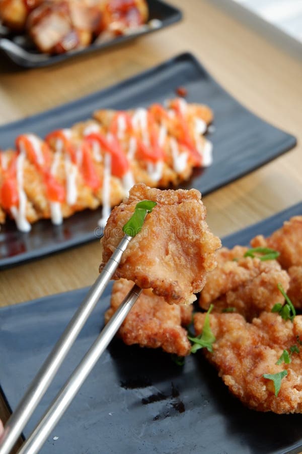 A Crispy Fried Chicken Taken Using Chopsticks Stock Photo - Image of ...