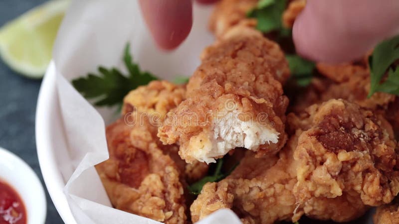 Man Eating Crispy Fried Chicken in a White Bowl with Tomato Sauce ...