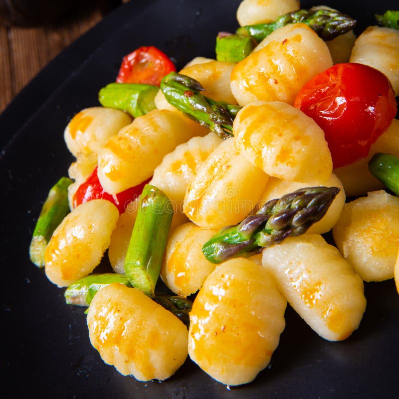 Crispy Gnocchi with Roasted Asparagus and Tomatoes Stock Photo - Image ...