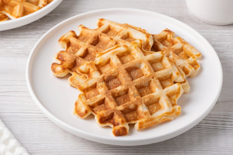 Crispy Golden Waffles Served on a Round White Plate in a Cozy Kitchen ...