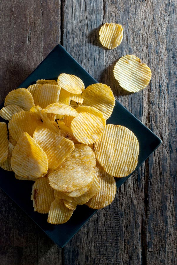 Crispy Potato Chips in a Black Square Ceramic Plate on a Rustic Wooden ...