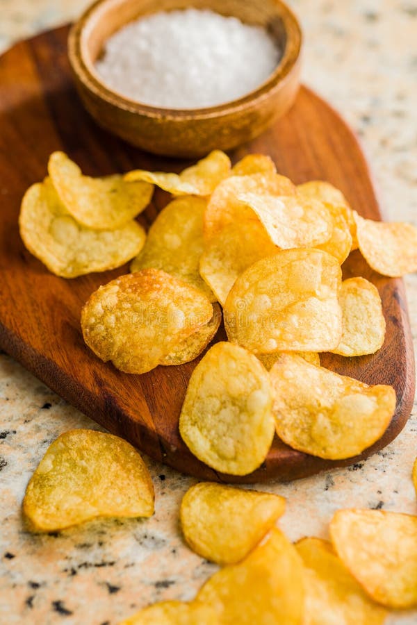 Crispy Potato Chips on Cutting Board on Kitchen Table Stock Image ...