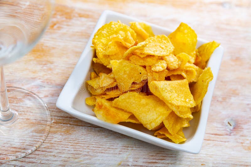 Crispy Potato Chips in White Square Ceramic Plate on Wooden Table Stock ...