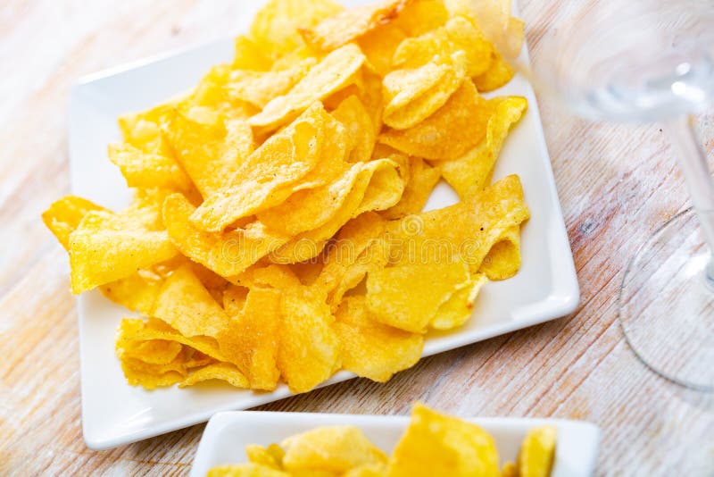 Crispy Potato Chips in White Square Ceramic Plate on Wooden Table Stock ...