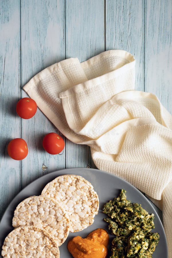 Crispy Puffed Rice Cakes on Table with Hummus Spread Spinach with Eggs ...