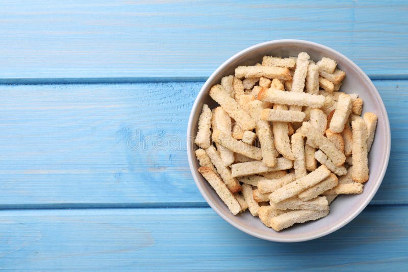 Crispy Wheat Rusks in Bowl on Light Blue Wooden Table, Top View. Space ...