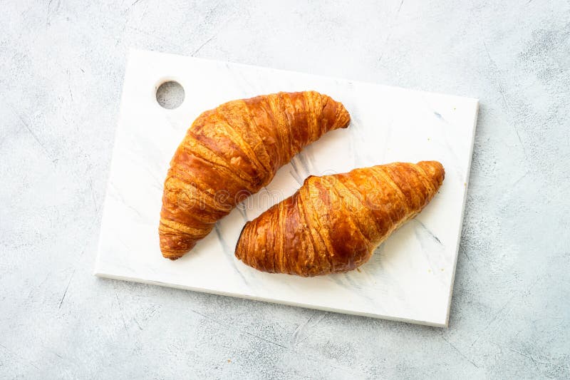 Croissant on Cutting Board at White Table Top View. Stock Image - Image ...