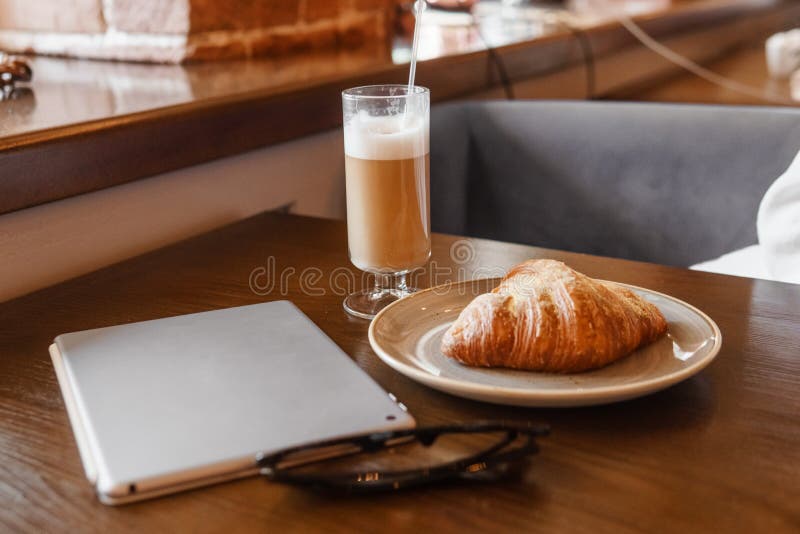 Croissant, Latte Coffee and Tablet on a Wooden Table in a Cafe. Stock ...