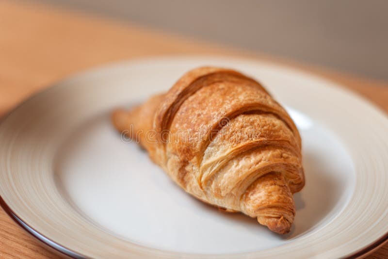 Croissant on a Plate on a Wooden Table Close-up Stock Image - Image of ...