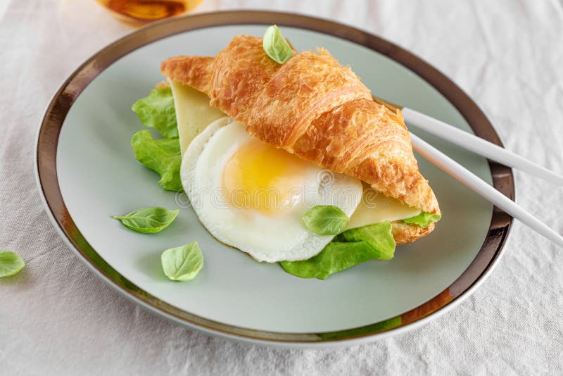 Croissant Toast with Lettuce, Cheese and Fried Egg on White Table ...