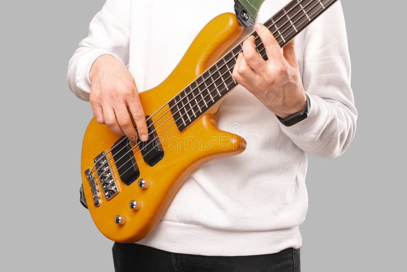 Crop Photo of a Man Wearing a Bass Guitar and Playing at it in a Studio ... Crop Photo of a Man Wearing a Bass Guitar and Playing at it in a Studio ...