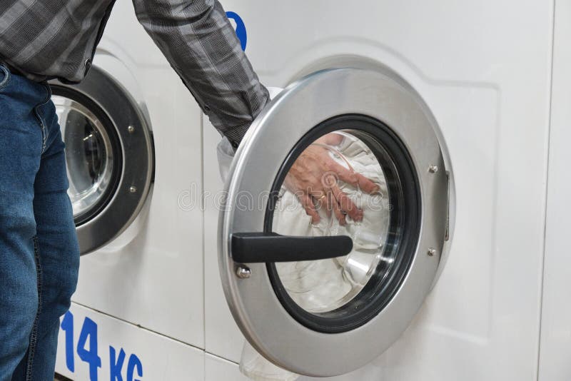 Cropped Hands of Man Putting Clothes in Washing Machine at Laundry ...