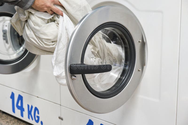 Cropped Hands of Man Putting Clothes in Washing Machine at Laundry ...