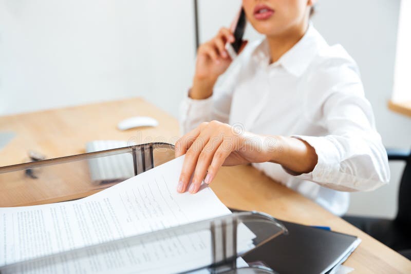 Cropped Image of Businesswoman Talking on Phone and Taking Documents ...