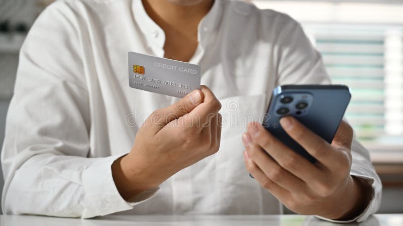 Cropped Image of Man Holding Using Mobile Phone and Credit Cad for ...