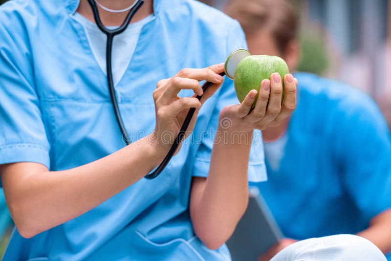 Cropped Image of Medical Student Examining Apple Stock Photo - Image of ...