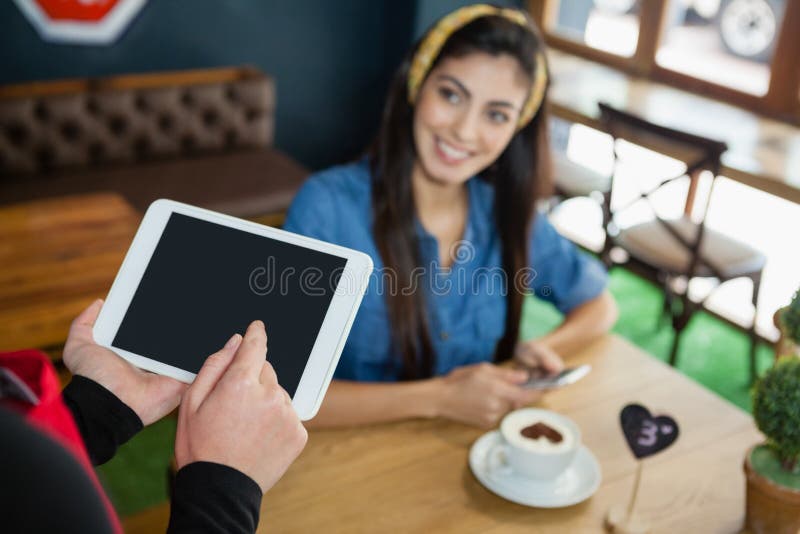 Cropped Image of Owner Holding Tablet while Customer Sitting at Table ...