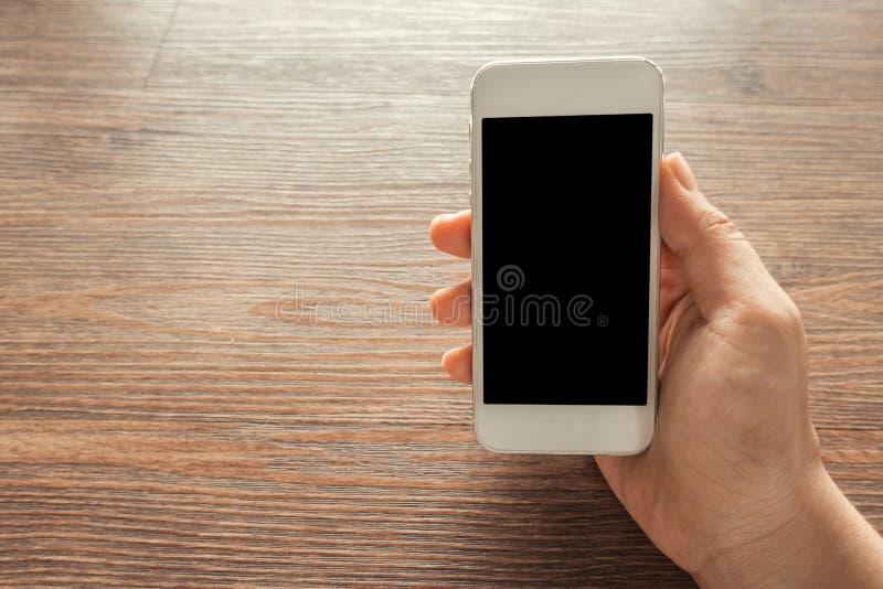 Cropped Image of Person Showing Mobile Phone at Desk Stock Photo ...