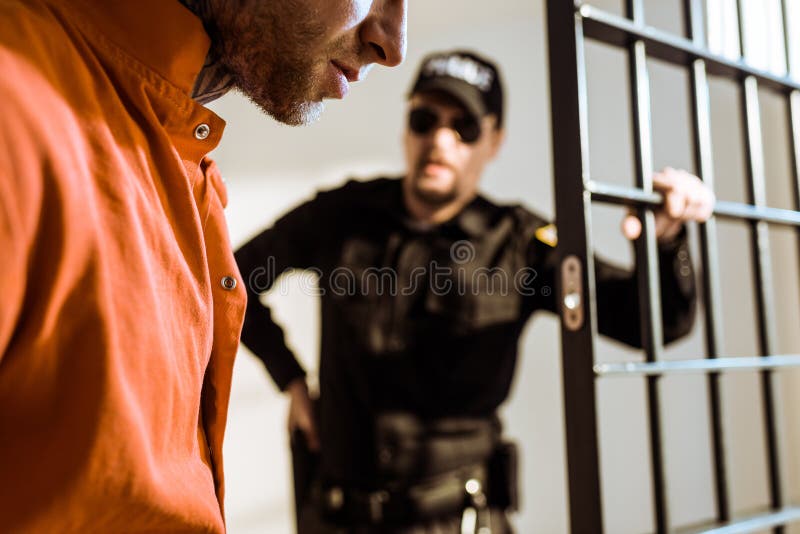 Cropped Image of Prison Guard Looking at Criminal Stock Photo - Image ...
