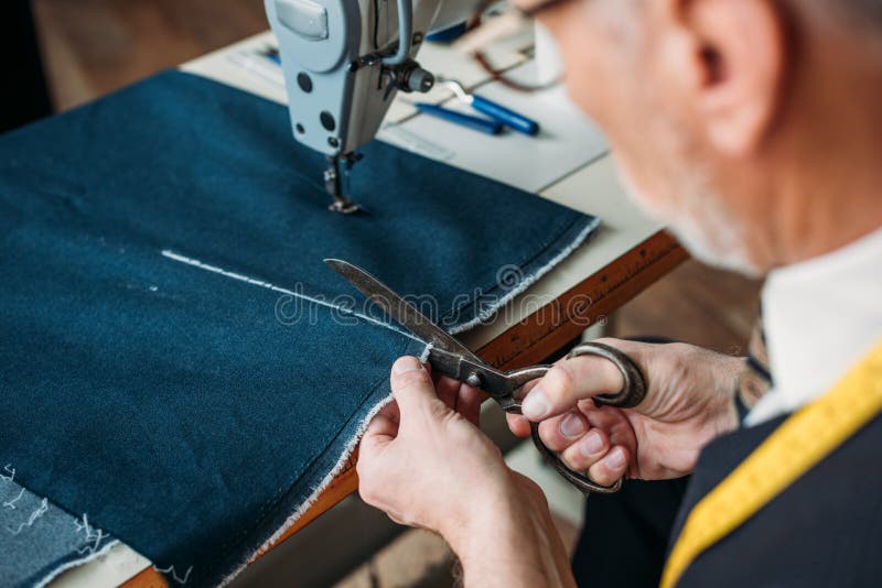 Tailor Cutting Fabric Using Large Scissors Or Shears As He Follows The ...
