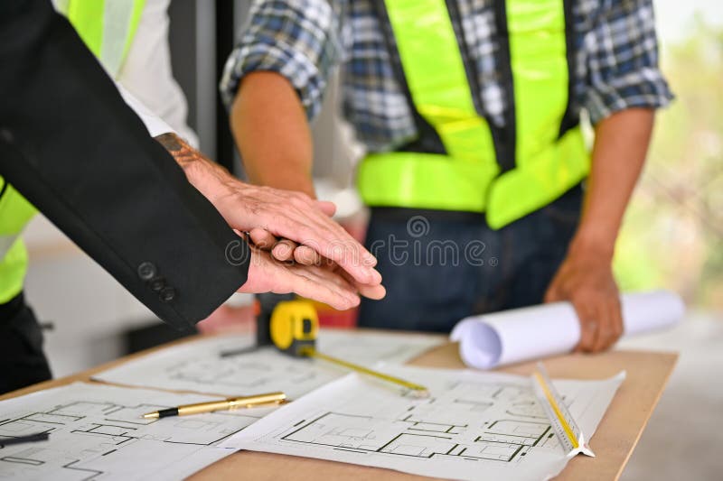 Cropped Image of a Team of Construction Workers Putting Their Hands ...