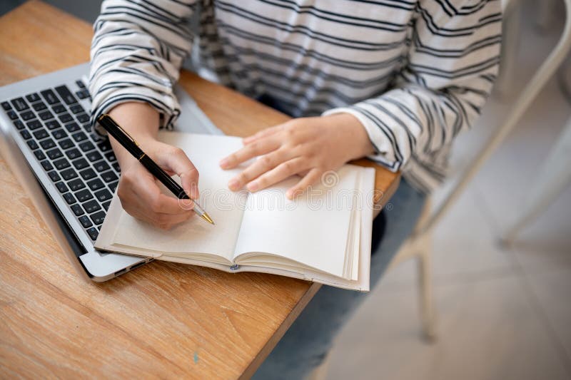 A Cropped Shot of a Female Student Doing Homework or Taking Notes in ...