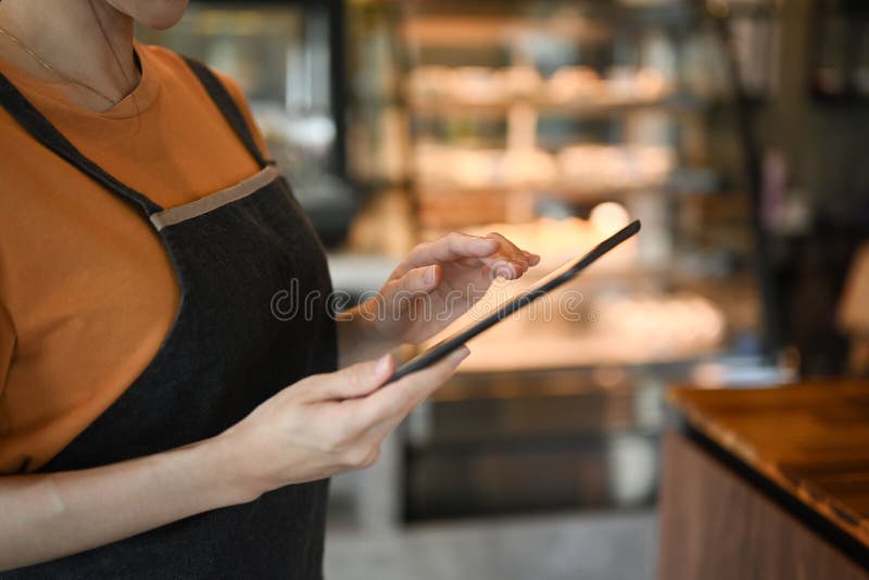 Cropped Shot of Female Waitresses in Apron Using Tablet and Checking ...