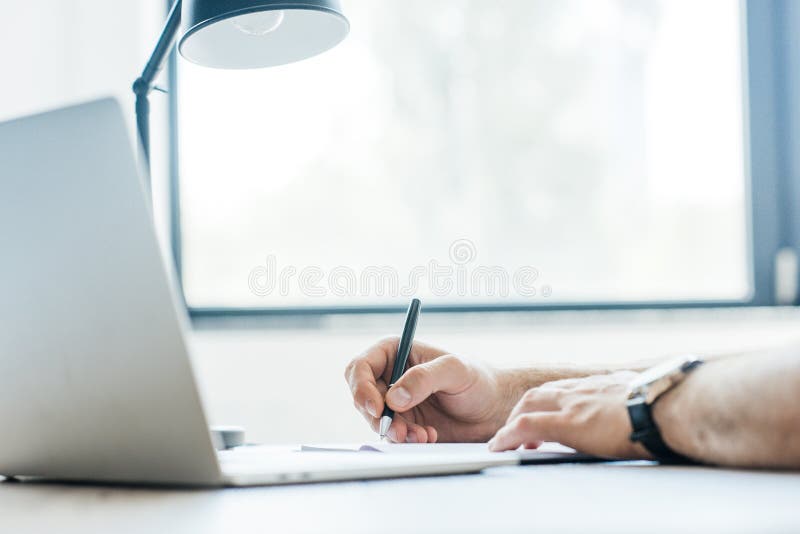 Cropped Shot of Person Taking Notes and Using Laptop Stock Image ...