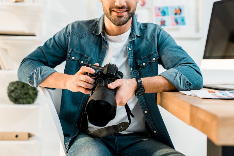 Cropped Shot of Smiling Young Photographer Holding Camera Stock Photo ...