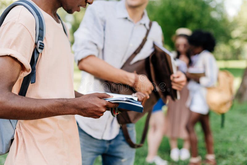Young Students Holding Textbooks while Standing in Park Stock Photo ...