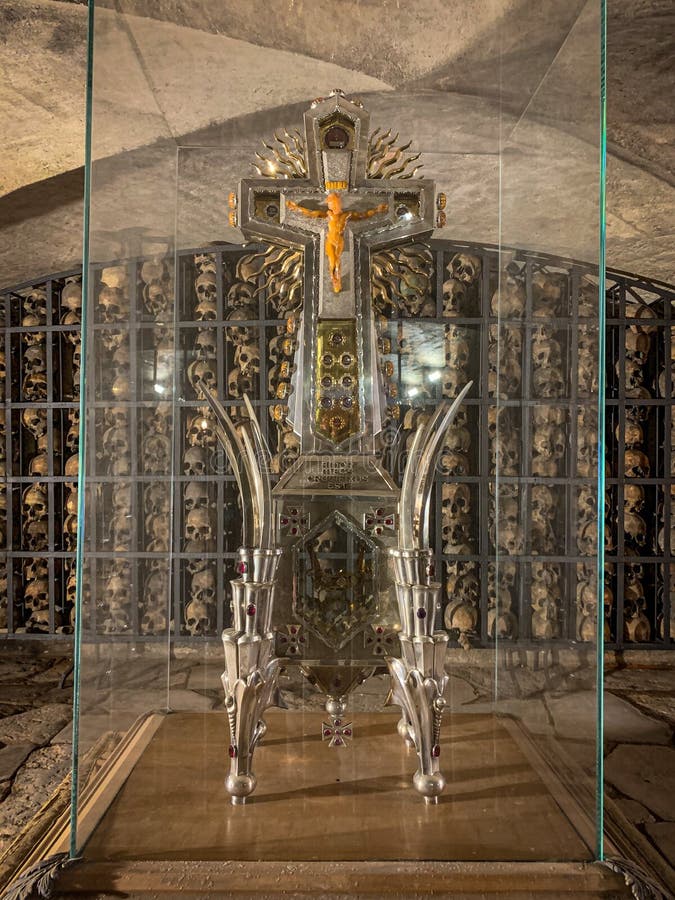 Cross in a Display Case and Skulls in the Background are in the ...