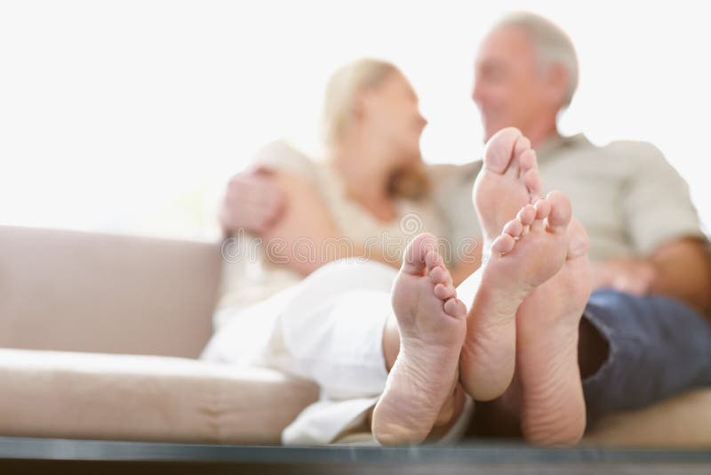 Crossed Feet of a Couple Sitting Together at Home Stock Image - Image ...