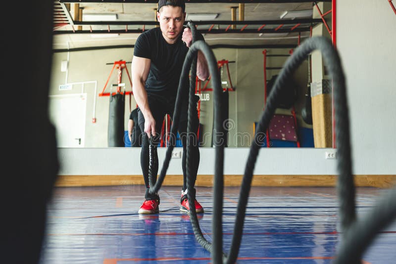 Crossfit with Ropes. the Athlete is Training in the Gym. Stock Photo ...