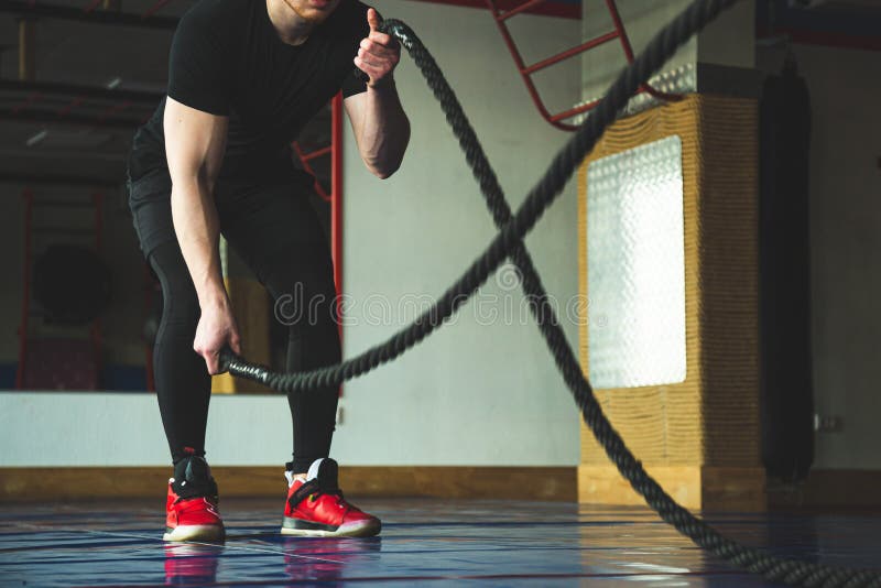 Crossfit with Ropes. the Athlete is Training in the Gym. Stock Photo ...