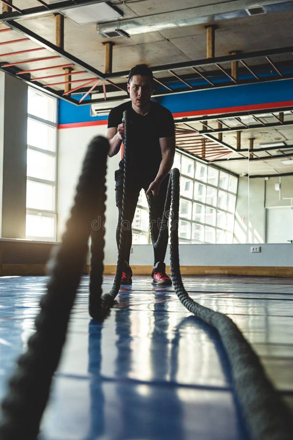 Crossfit with Ropes. the Athlete is Training in the Gym. Stock Image ...