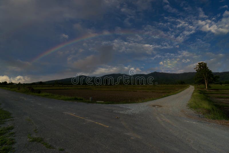 Crossroads in a Rural Road on the Background of the Sky and Rainbow ...