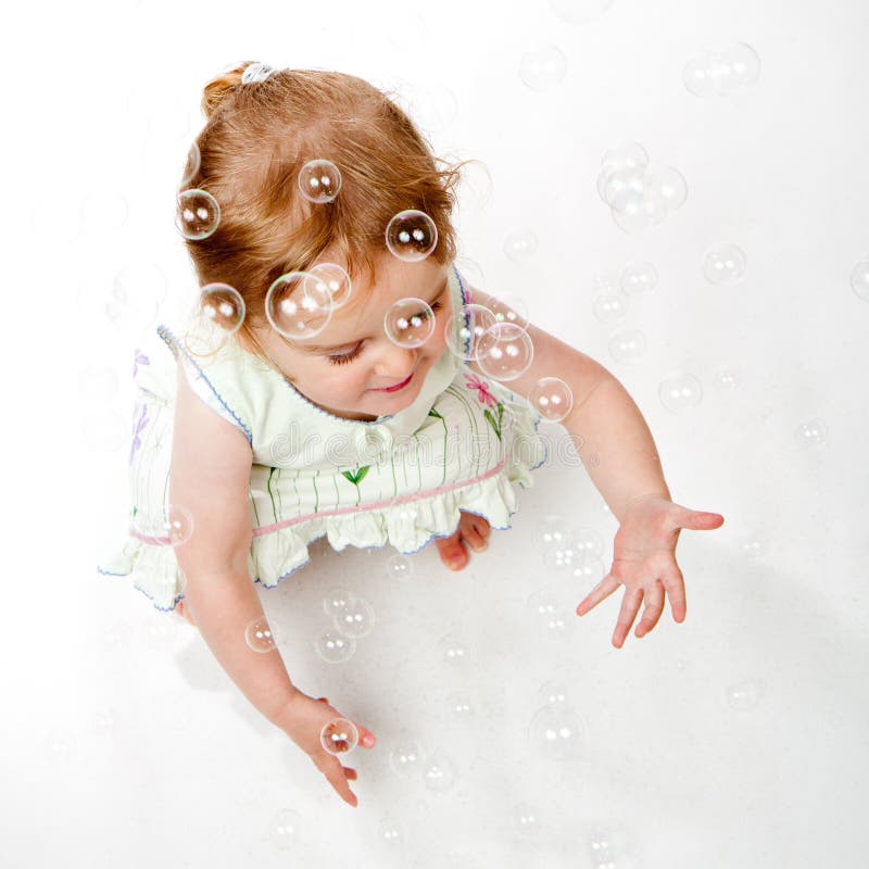 Crouching 2 Year Old Girl Catching Bubbles Stock Photo - Image of ...