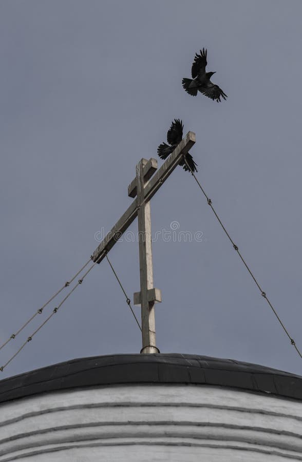 Crow flying over the cross stock photo. Image of symbols - 231483270
