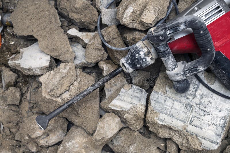 The Crowbar and Jackhammer Lies on Large Pieces of Broken Cement Walls ...