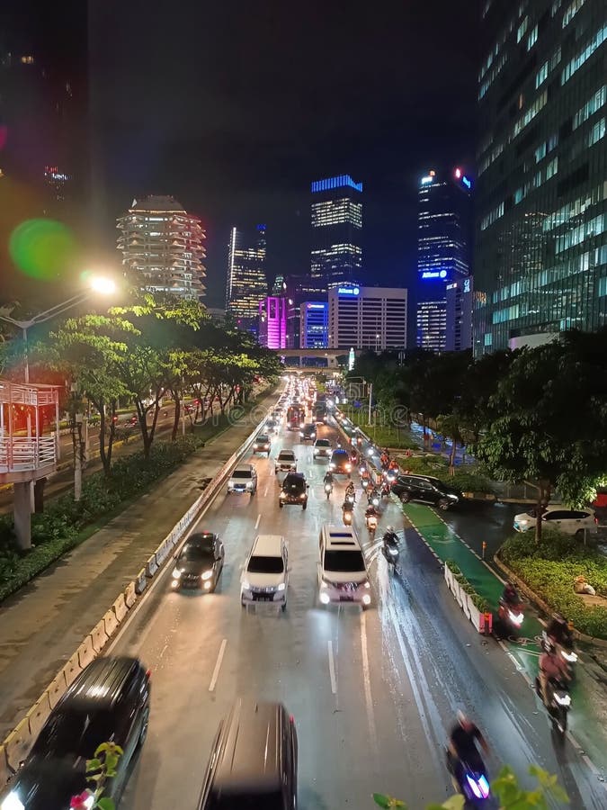 Crowded Traffic in the City Center at Night with with a Building ...