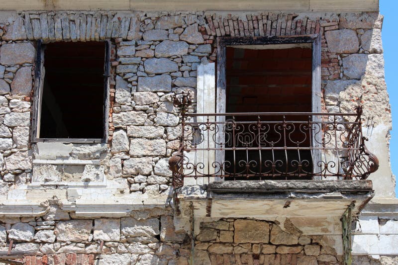 Crumbling Stone Building Facade with Missing Windows and Rusty Balcony ...