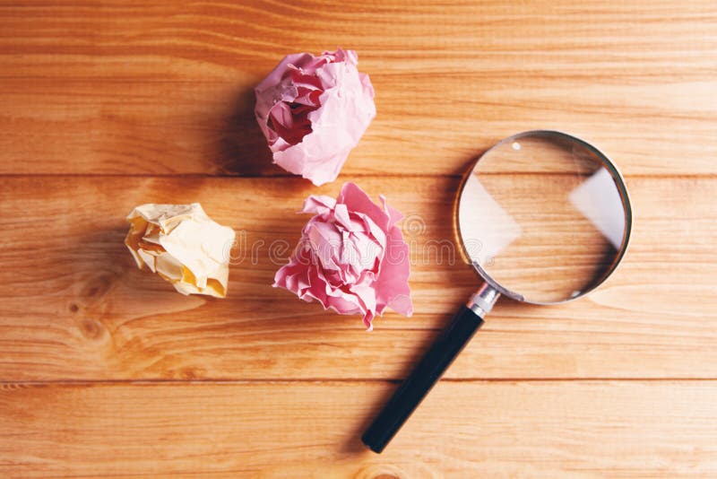 Crumpled Papers and a Magnifying Glass Stock Photo - Image of ...